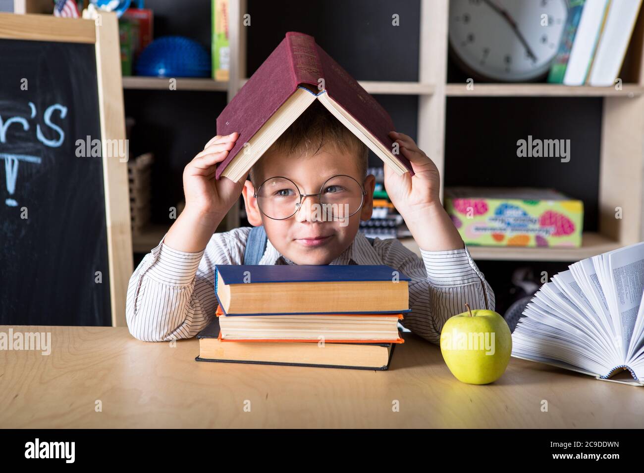 Cute Kid is learning in class on background of blackboard. Teachers day ...