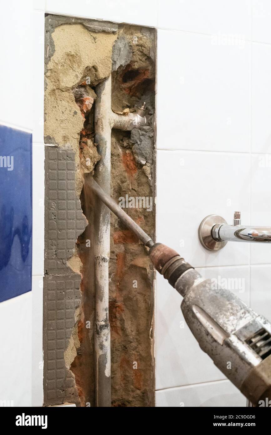 repairing of plumbing riser of heated towel rail at home - chiseling a ...