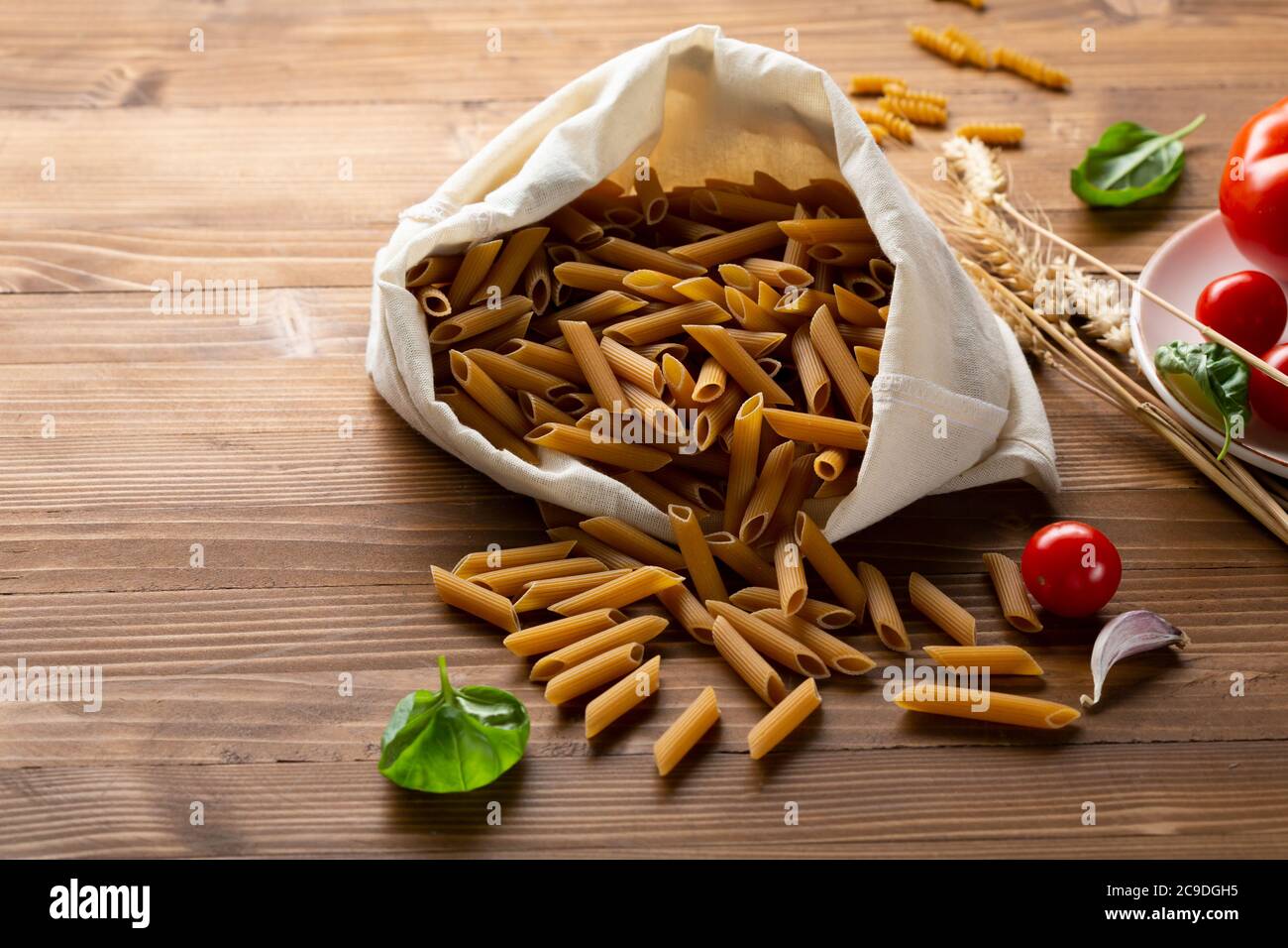 Whole grain penne pasta in white cotton storage bag Stock Photo - Alamy