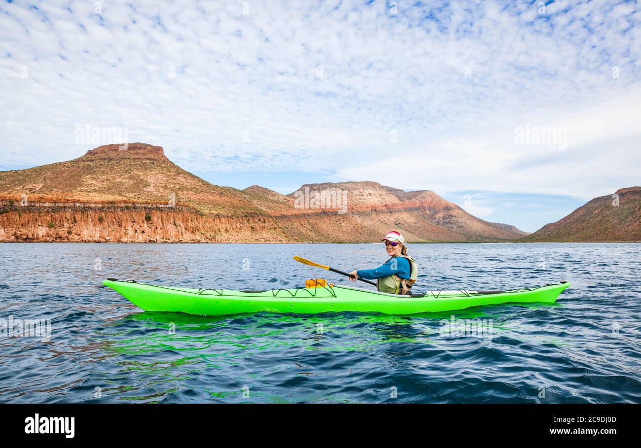 A woman sea kayaking off shore of Isla Espirito Santo, Gulf of ...