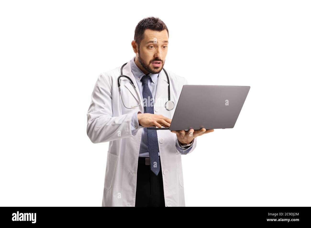 Shocked male doctor looking at a laptop computer isolated on white ...