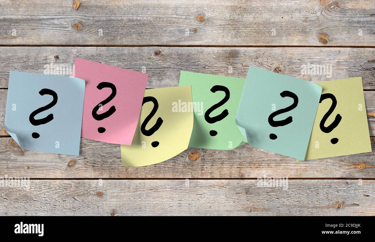Wooden wall with sticky notes with question marks Stock Photo - Alamy