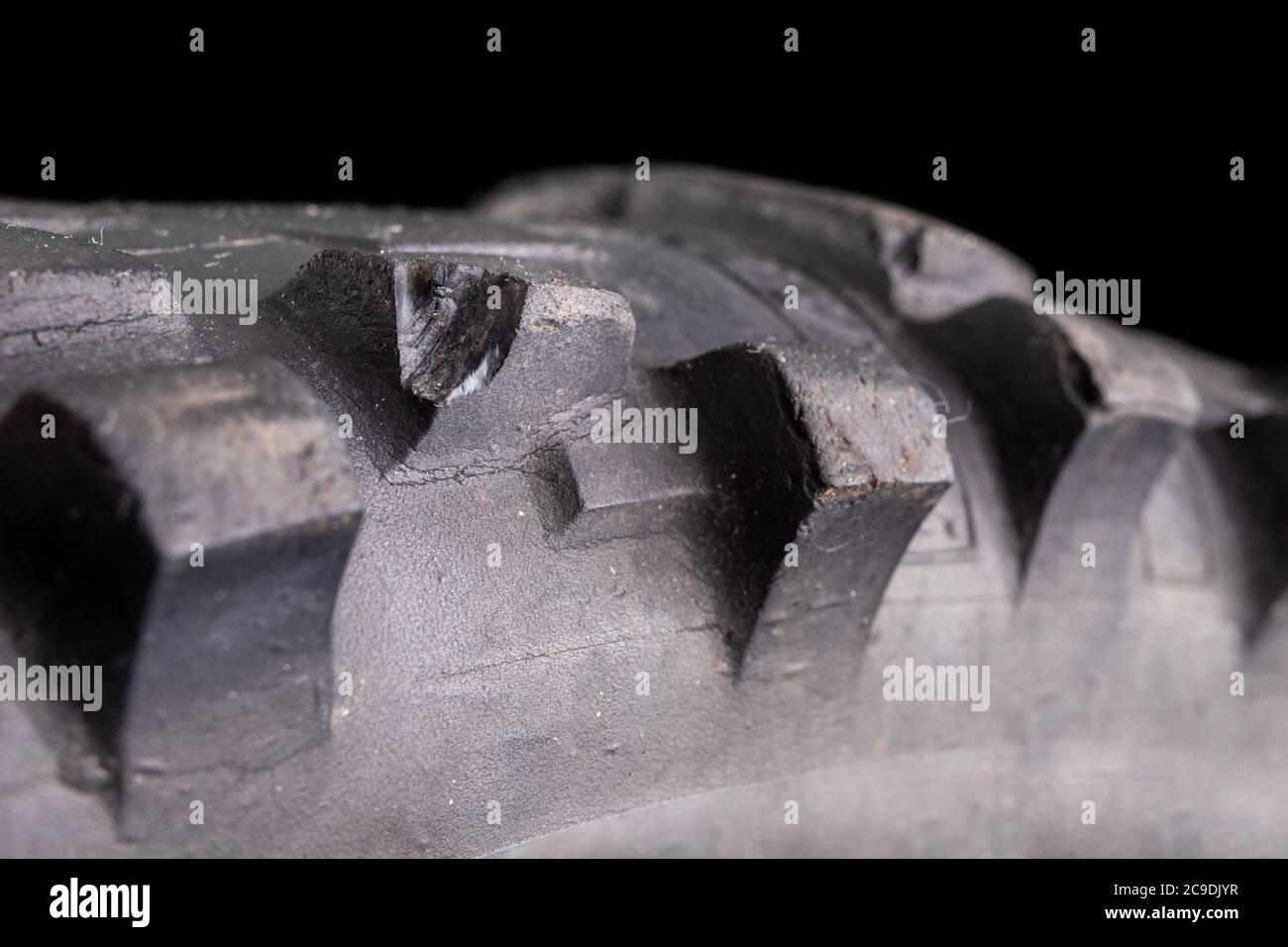 Damaged tread in a motocross tire. Damaged tire with high tread. Dark ...