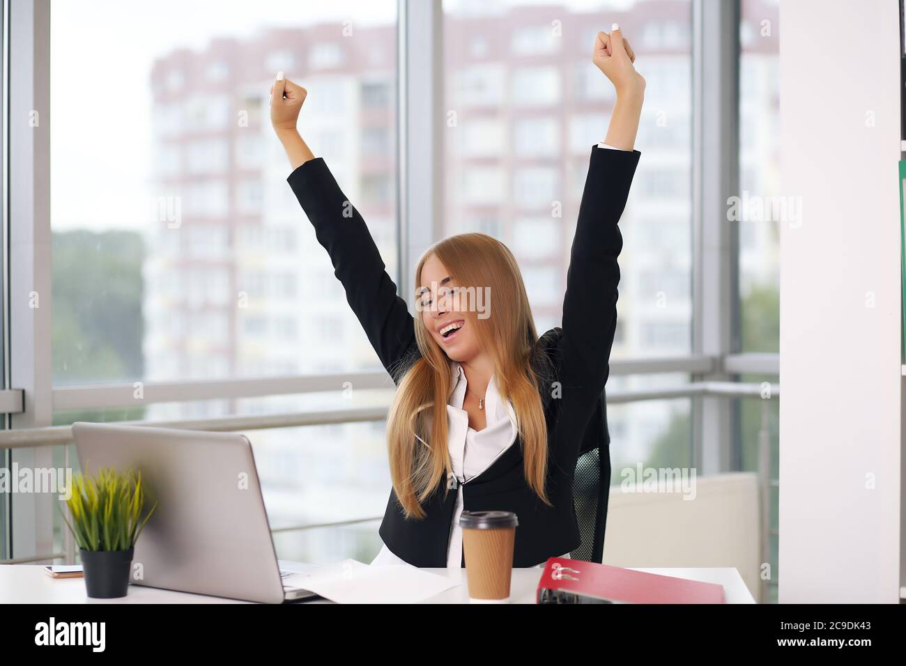 blonde in a suit rejoices, hands up, business lady, office Stock Photo ...