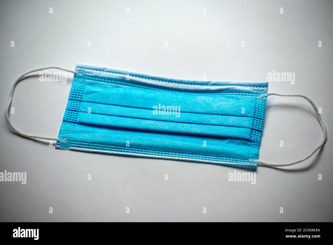 Blue surgical mask on white background Stock Photo - Alamy