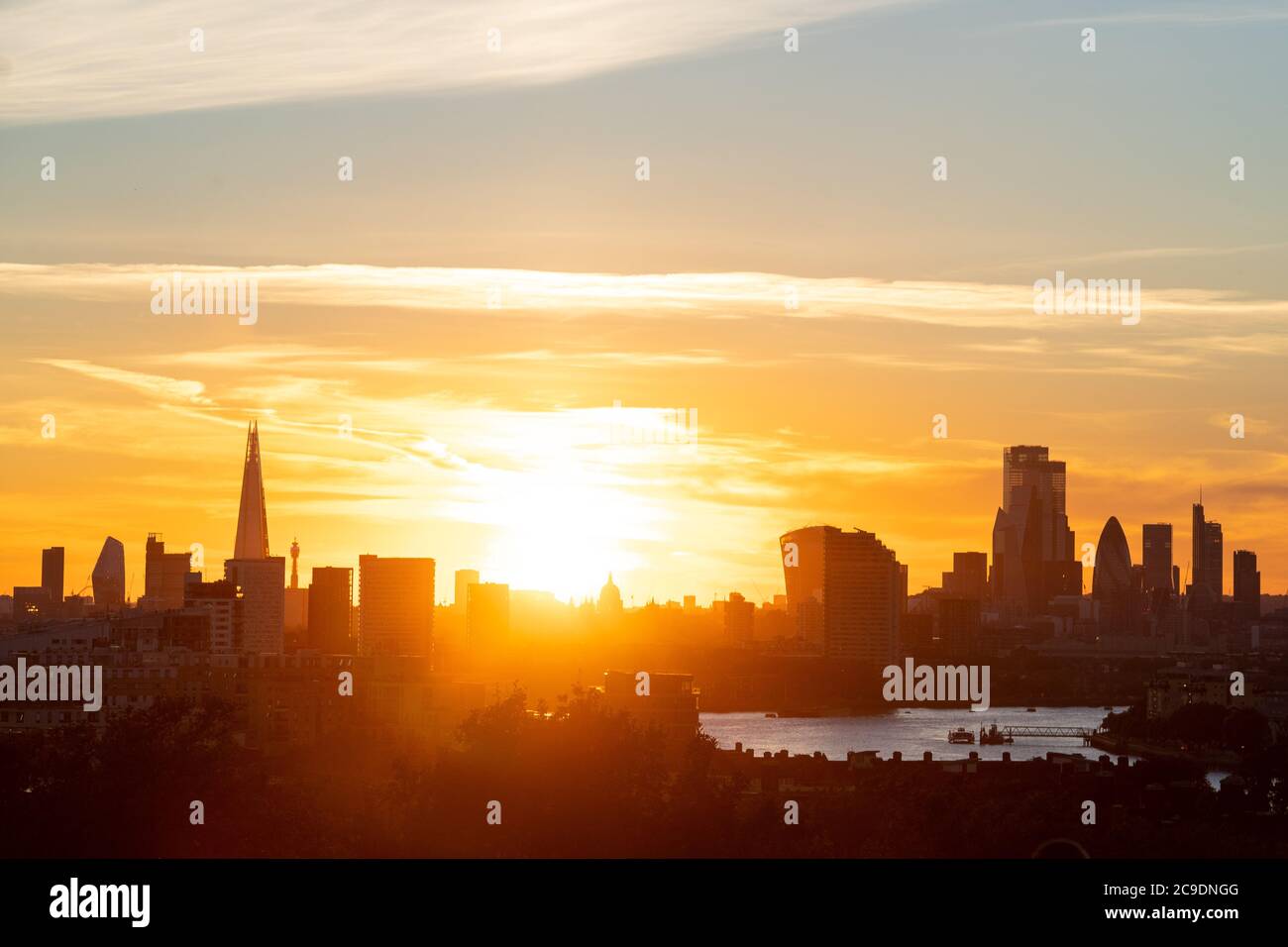 The sun sets behind skyscrapers on the London skyline, including (from ...
