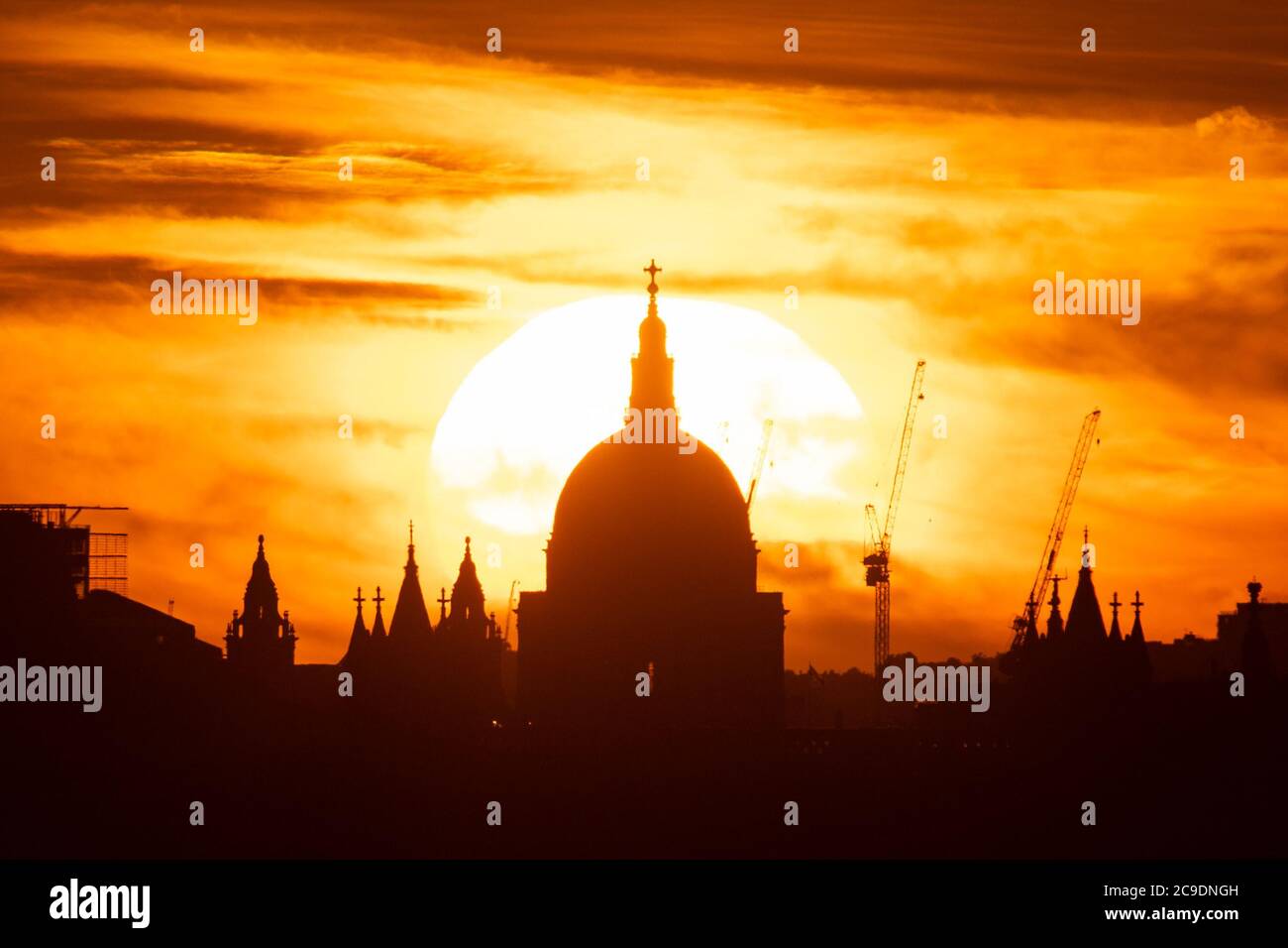 The sun sets behind the dome of St Paul's Cathedral, in London, on the ...