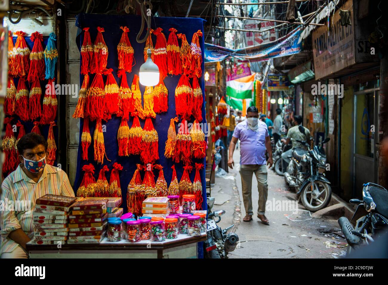 Bunches of rakhis for sale are hanged on a rope in front of a shop ...