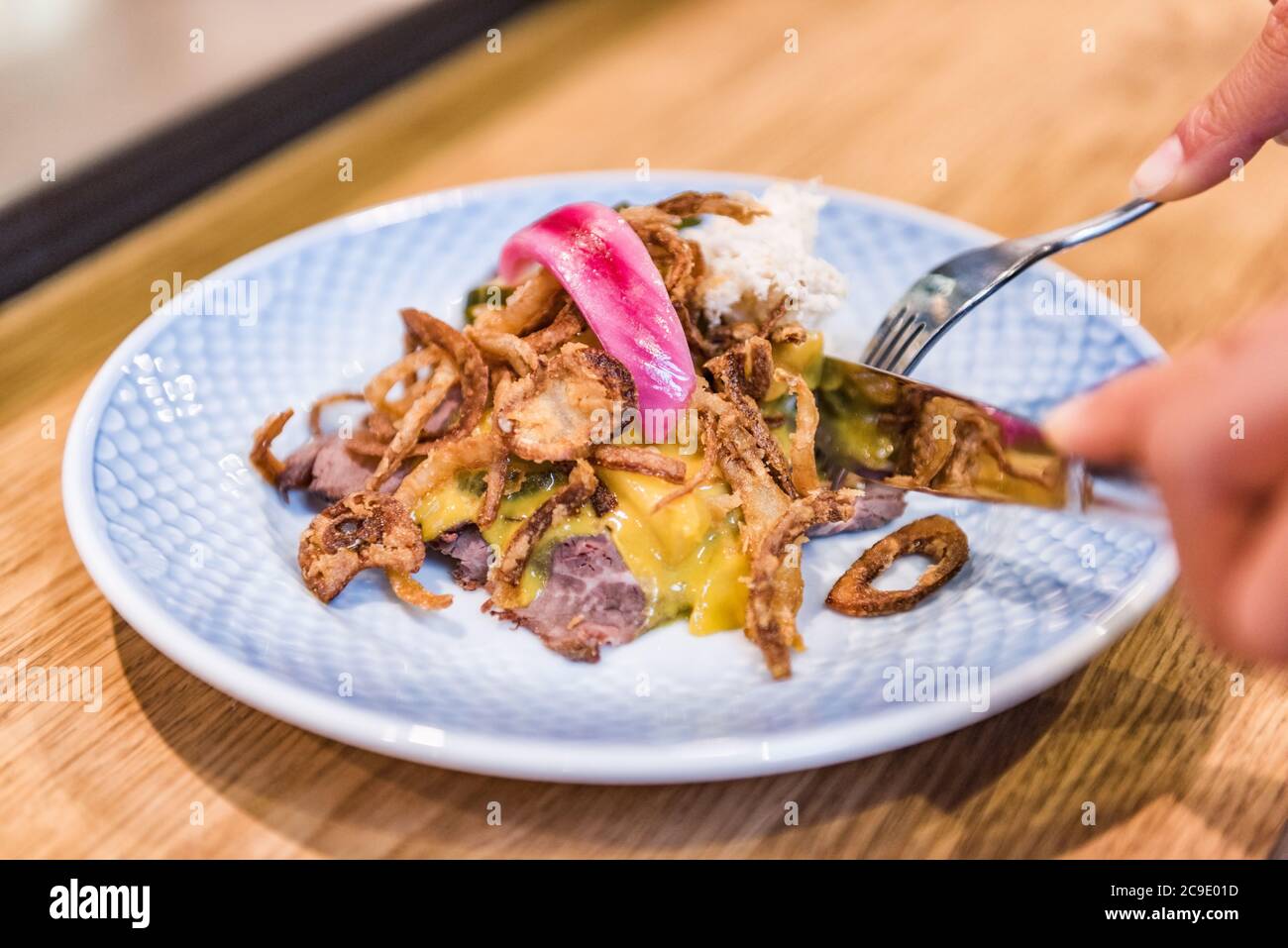 Danish food smorrebrod open sandwich woman eating at restaurant. Person ...