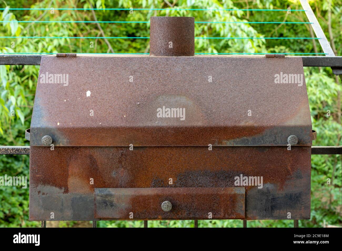 Old rusty large size barbecue grill with ash tray and chimney hanging ...