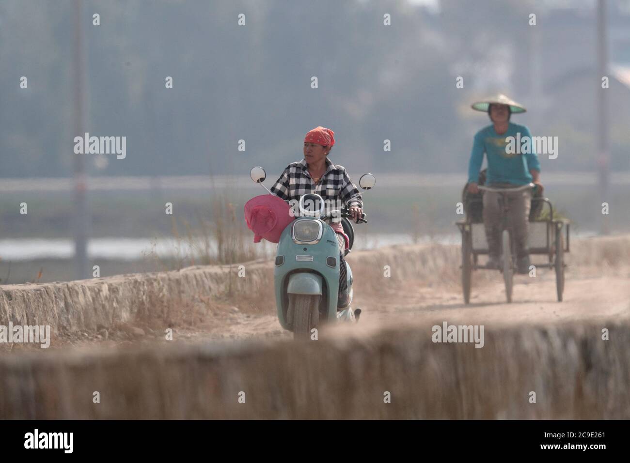Woman on motor scooter, Yingjiang River floodplain, Yingjiang county ...