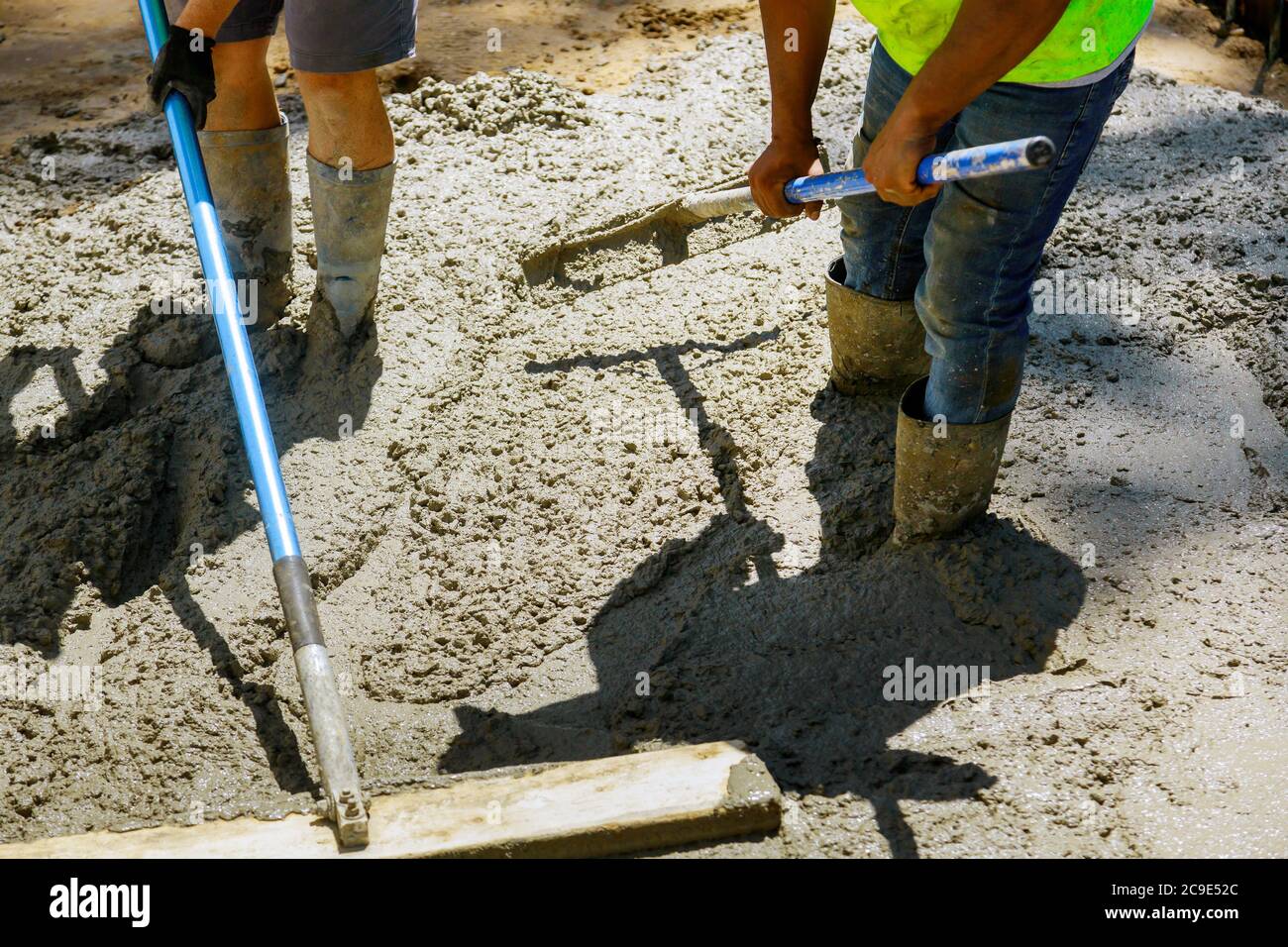 Construction mason building a screed coat cement a laborer floats a new ...
