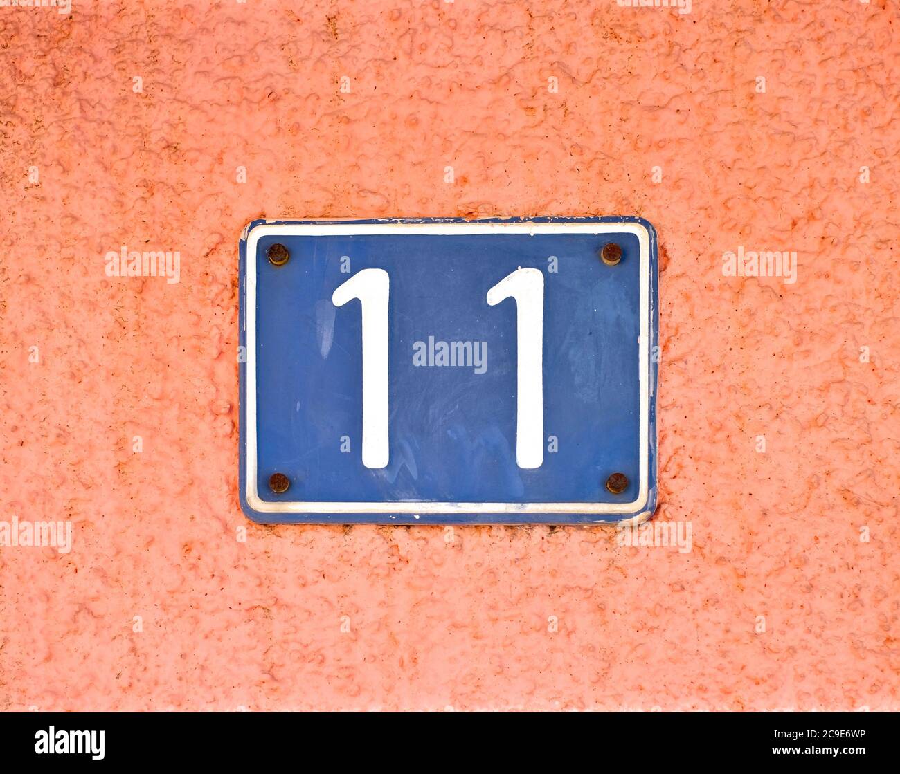 Number 11 / eleven, blue plate on pale pink wall surface Stock Photo ...