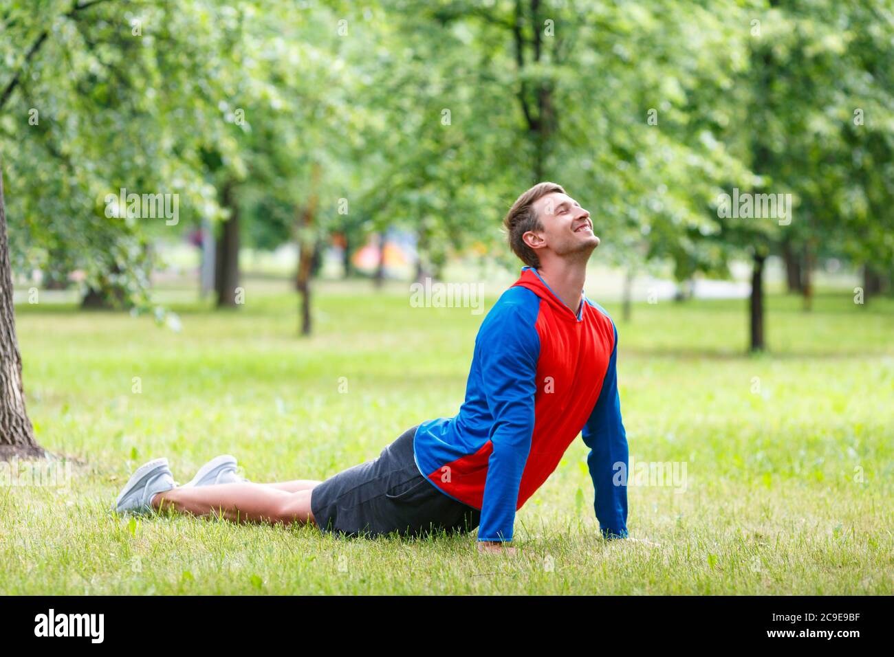 Yoga man in cobra upward facing dog pose stretching abs stomach muscles ...