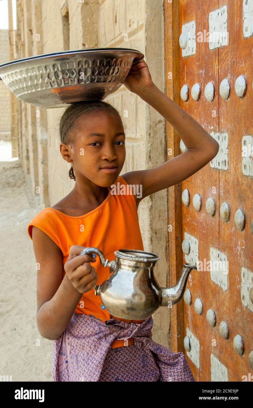 A local girl is bringing tea to a house in Timbuktu, Mali, a city on ...