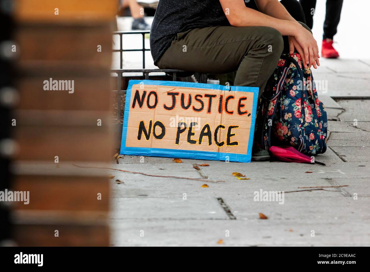 A sign says "No justice, no peace," at a march sponsored by Concerned ...