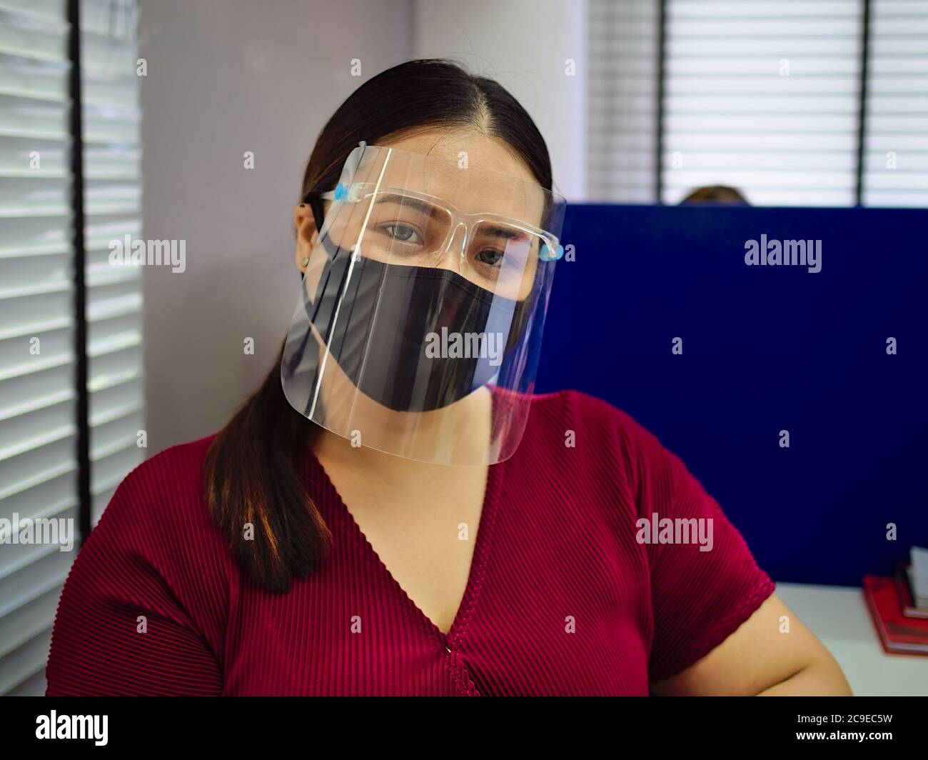 A young and beautiful Asian woman wearing a surgical mask and face ...