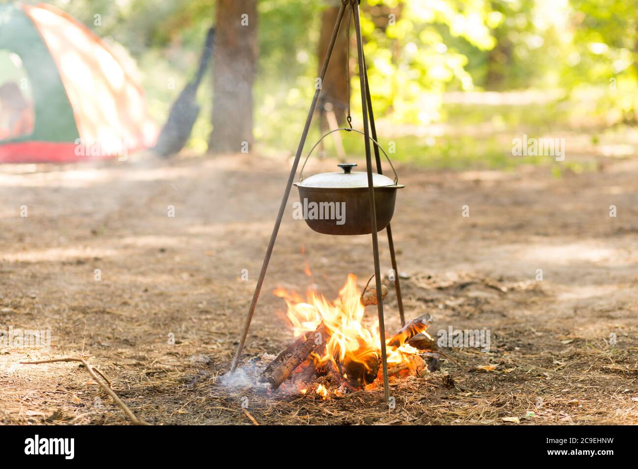 Hiking pot in bonfire with blue tent in autumn forest traveling Stock ...