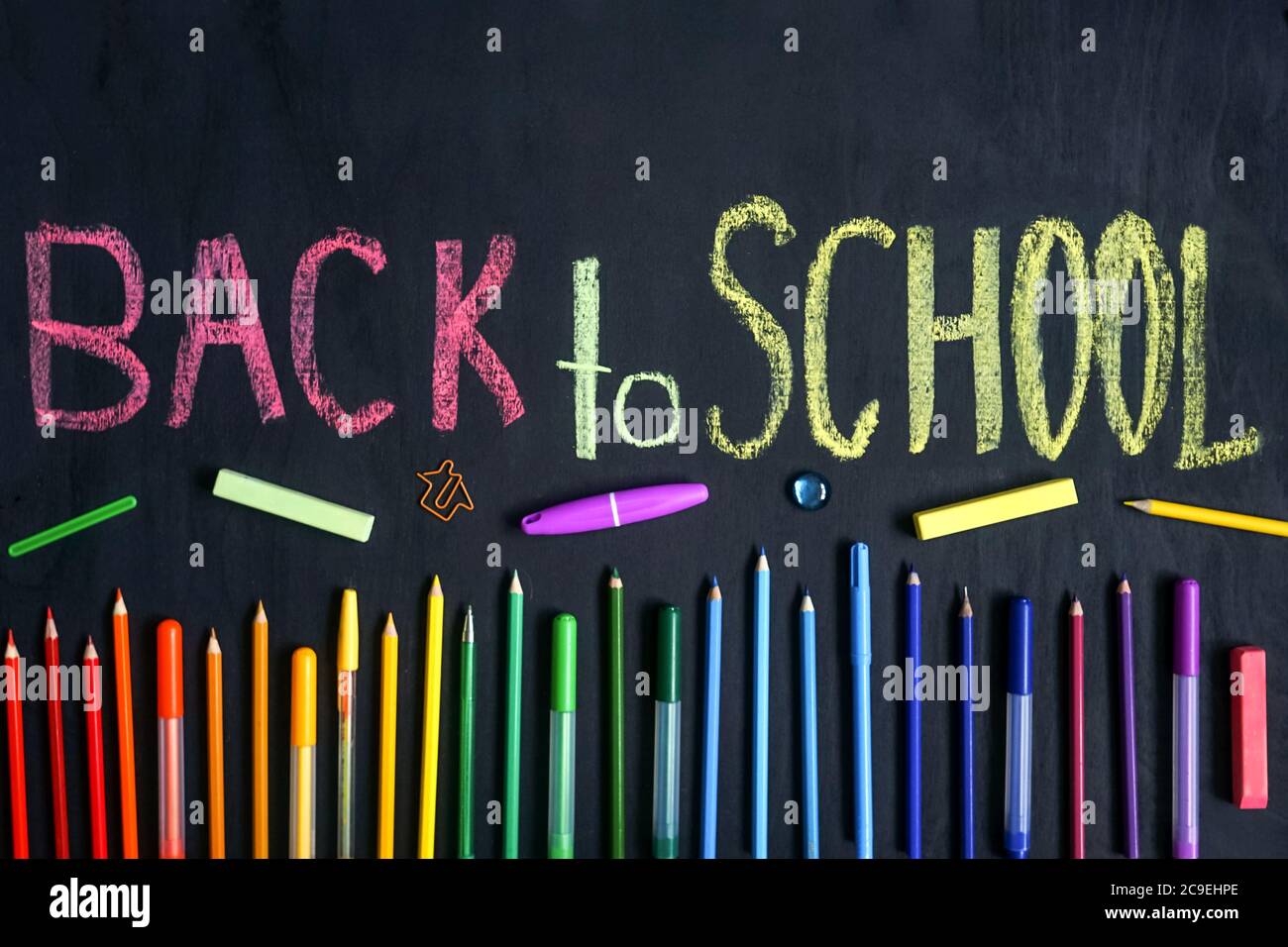 Colorful stationery on black. Flat lay. Row of tools, gradient rainbow ...