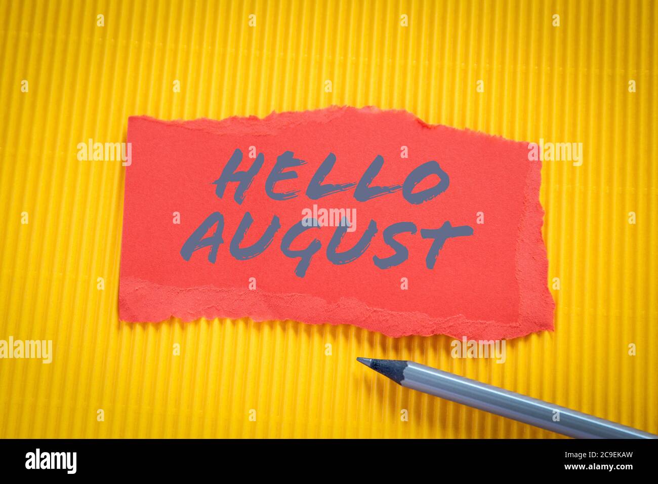 Hello August. Text on torn, colored paper on corrugated background ...