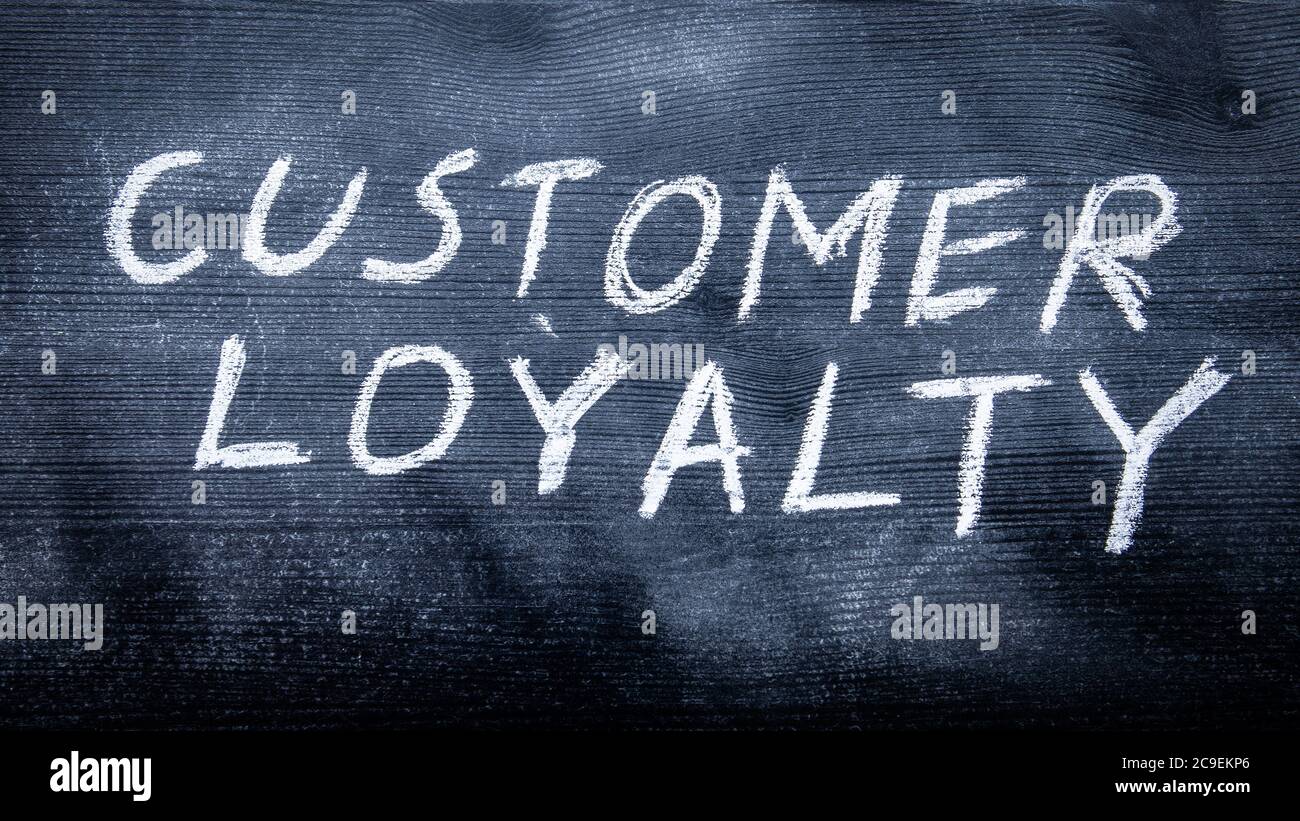 CUSTOMER LOYALTY concept. Black painted wood and inscription with chalk ...