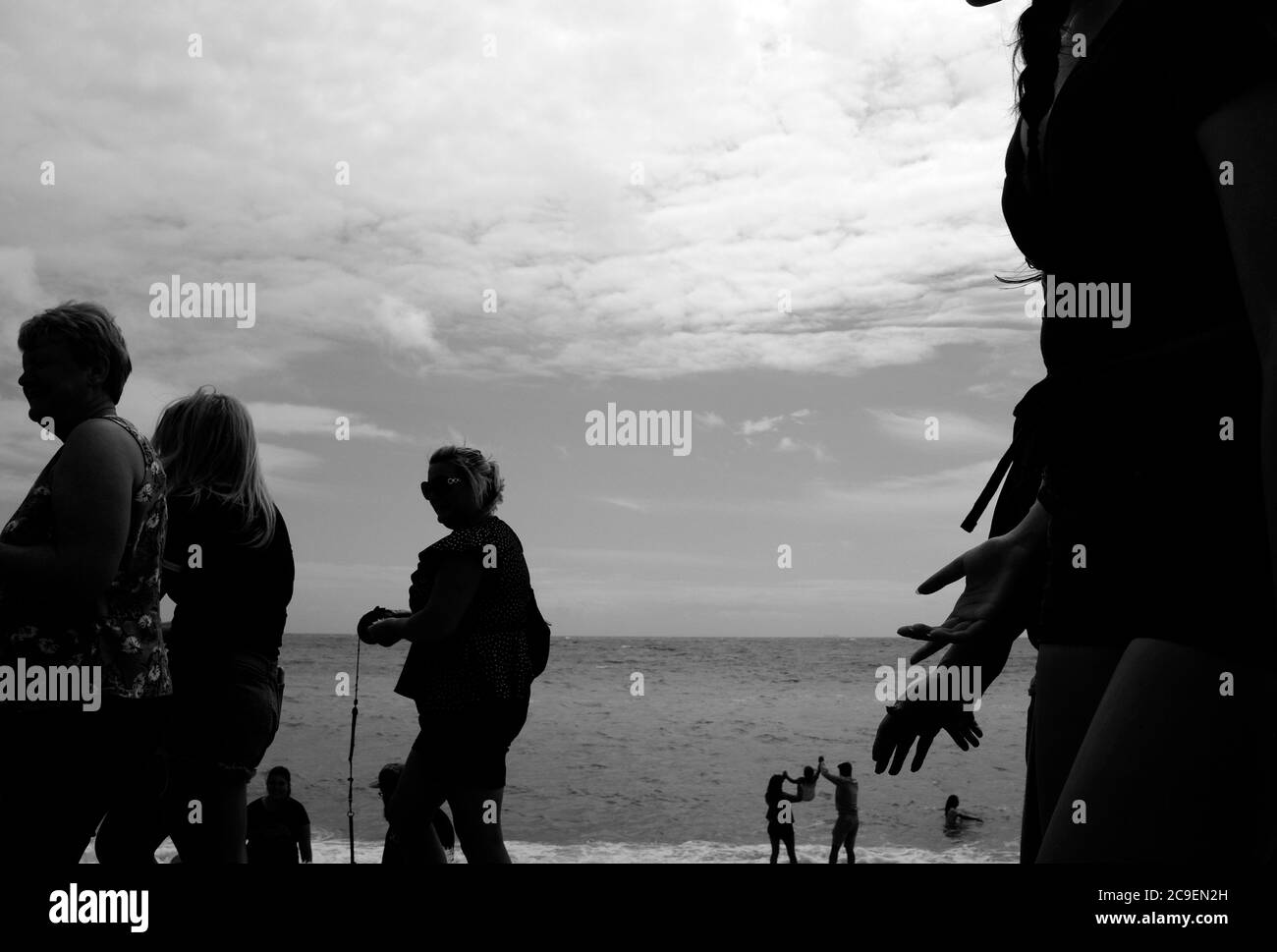 Beachgoers promenading along the revetment sea wall fully dressed at ...