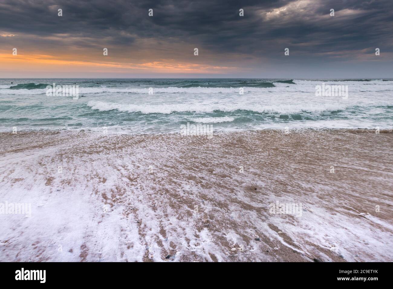 Evening light over the incoming tide at Fistral Beach in Newquay in ...