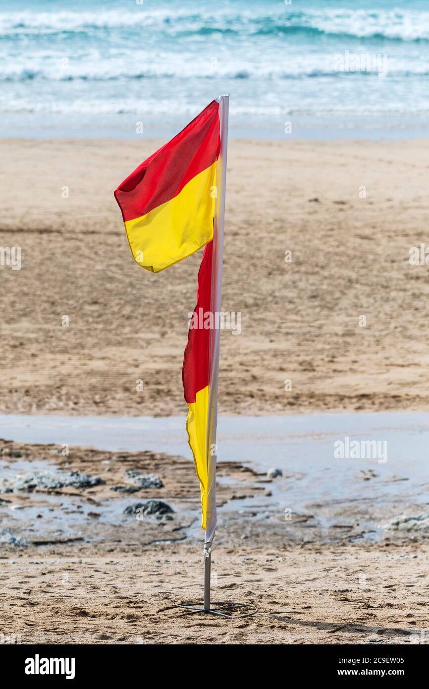 A red and yellow warning flag on Fistral Beach in Newquay in Cornwall ...