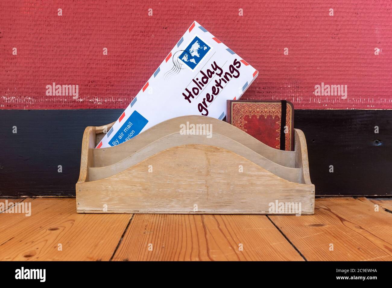 Holiday greetings on an envelope in an vintage wooden letter holder ...