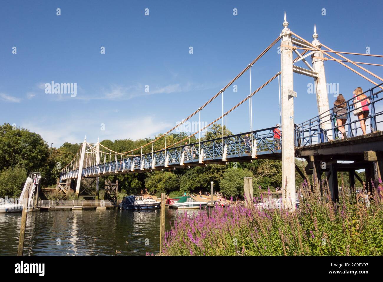 Girls walking across Teddington Lock Footbridge on the River Thames ...