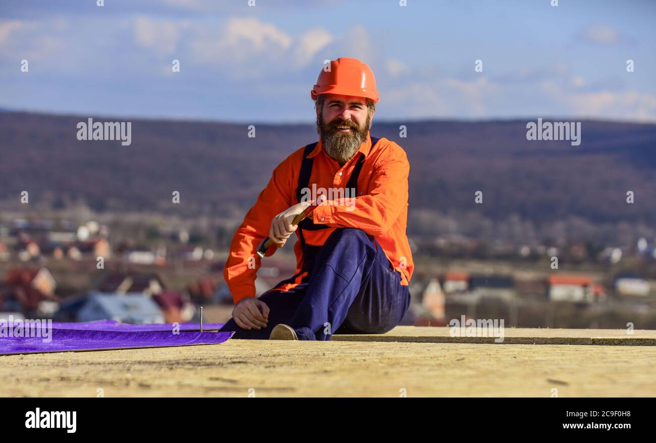 in work clothes. roofer working on roof structure of building on ...