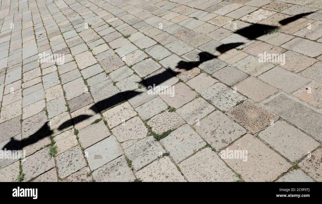 series of shadows of clothes hanging out to dry in the sun in summer in ...