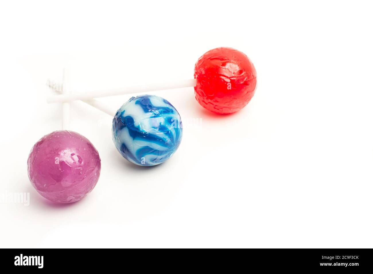 Three colored lollipops isolated on a white background Stock Photo - Alamy