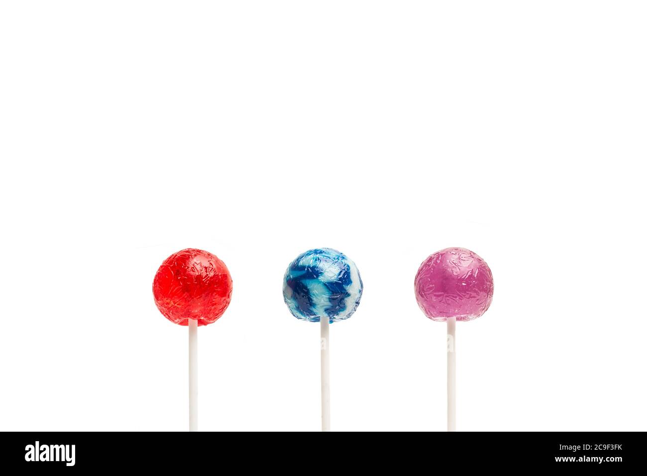 Three colored lollipops isolated on a white background Stock Photo - Alamy