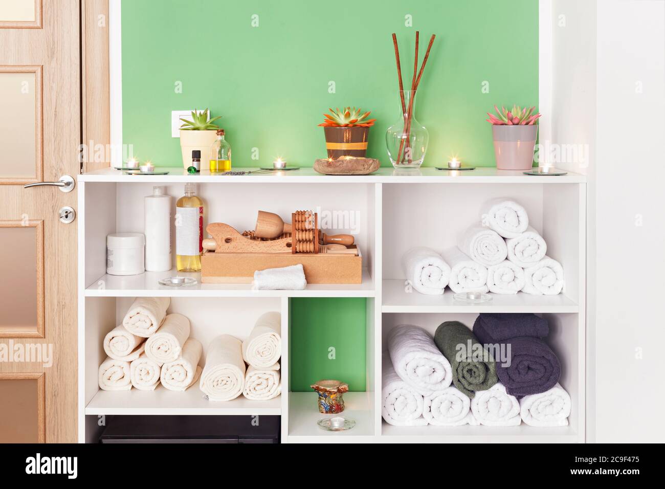 Rolled bath towels laying on the shelf in spa salon with Madero therapy ...