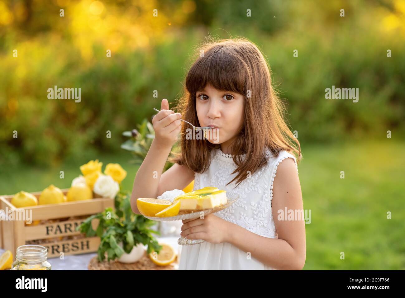 Girl eating lemon cake Stock Photo - Alamy