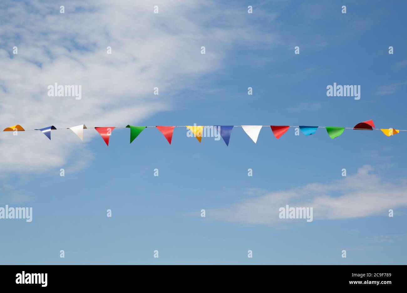 Colored triangular flags on blue sky background Stock Photo - Alamy