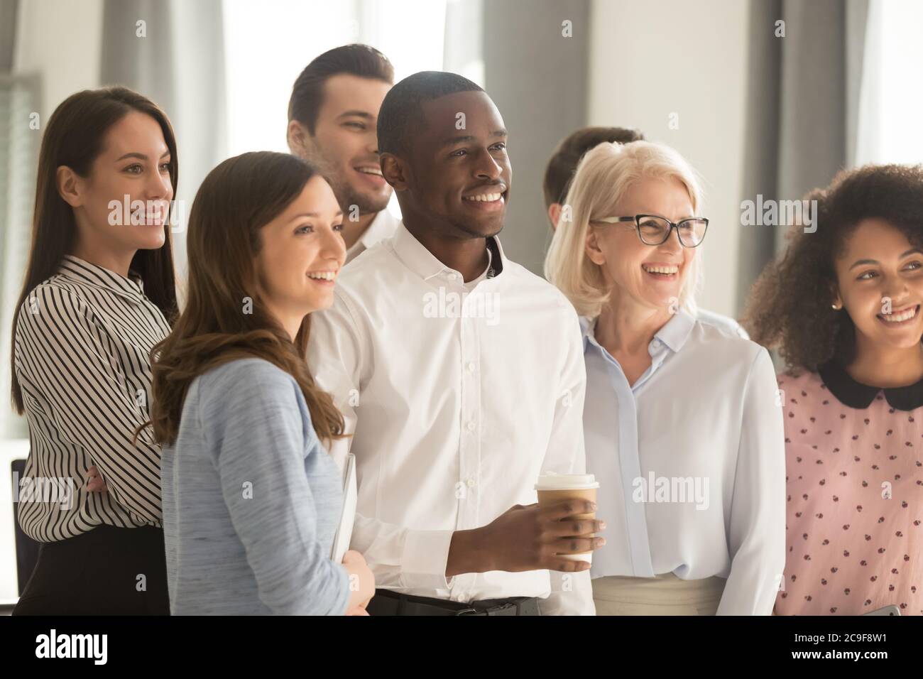 Smiling diverse employees team posing for company photo in office Stock ...