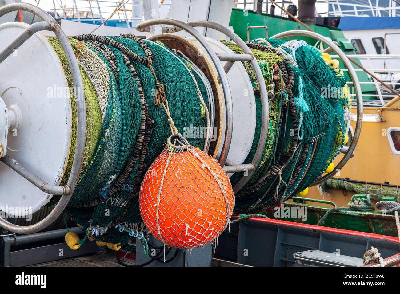 Rolled fishing nets in a fishing trawler in the small trading port of ...