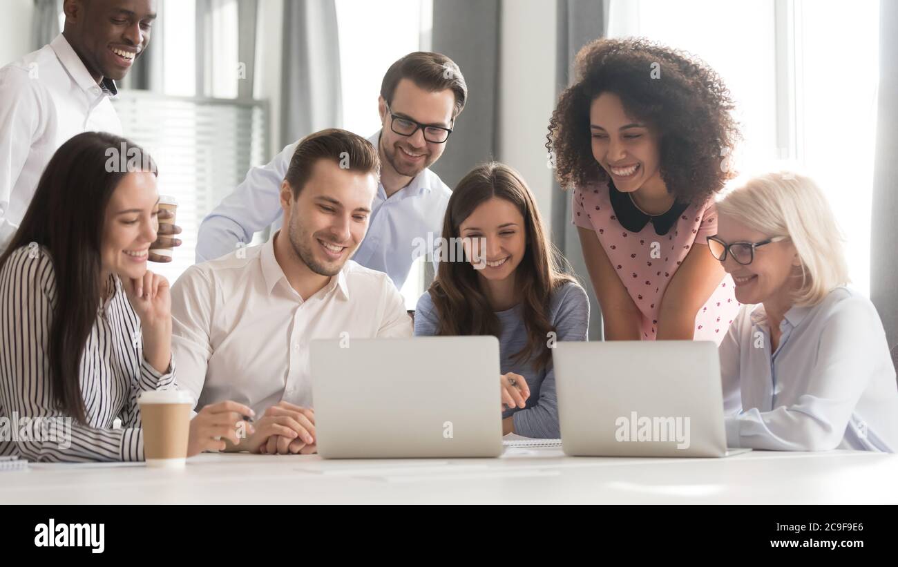 happy-smiling-diverse-employees-using-laptop-watching-webinar-together