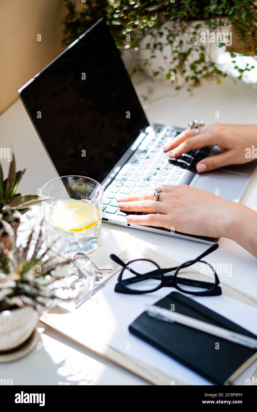 Woman's hands on laptop keyboard, cozy workplace Stock Photo - Alamy