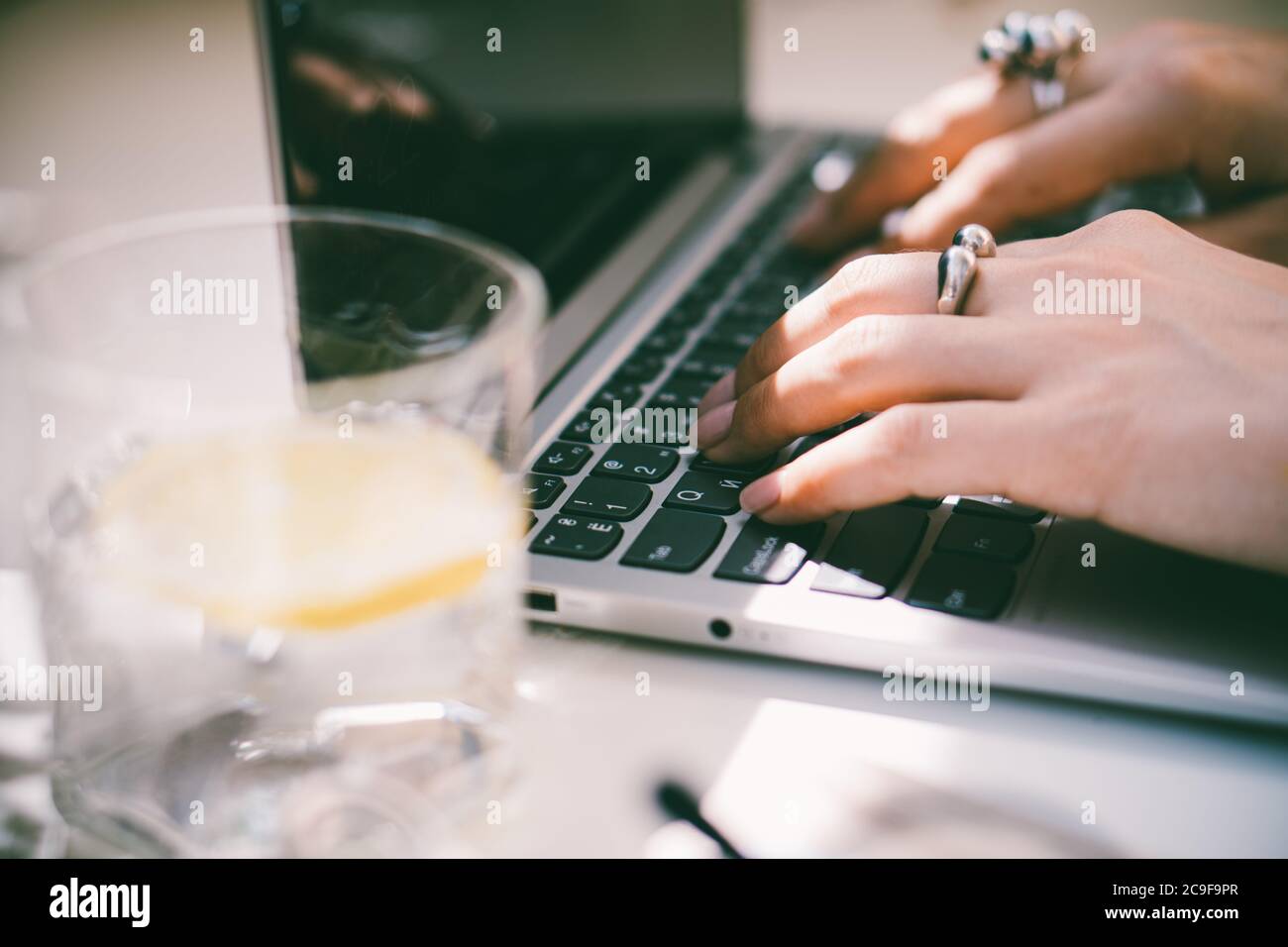 Woman's hands on laptop keyboard, cozy workplace Stock Photo - Alamy
