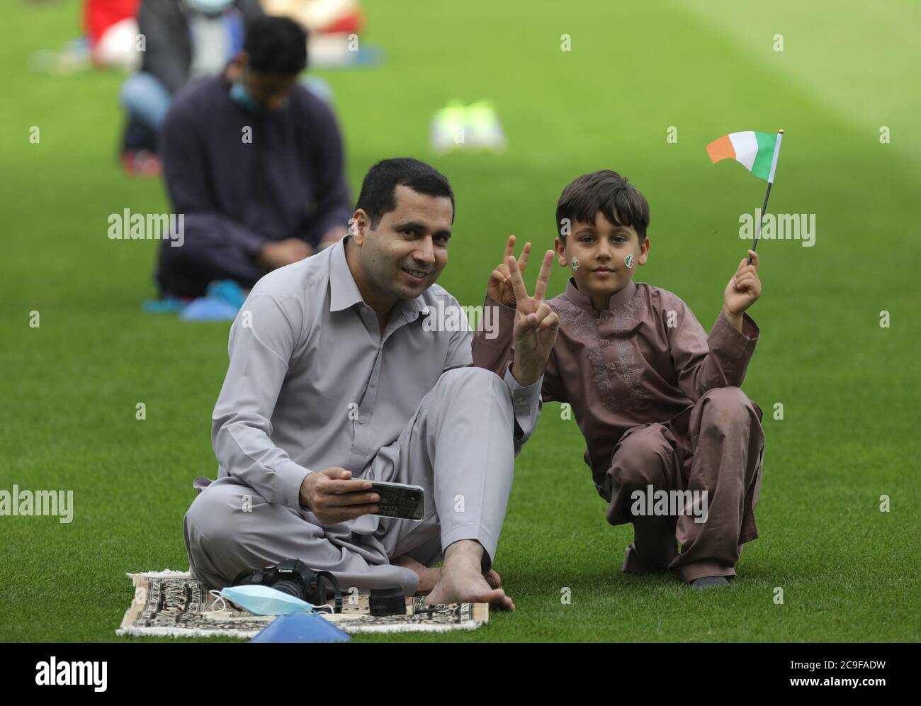Kamil Ayub (right), aged 6, holds an Irish flag alongside his father ...