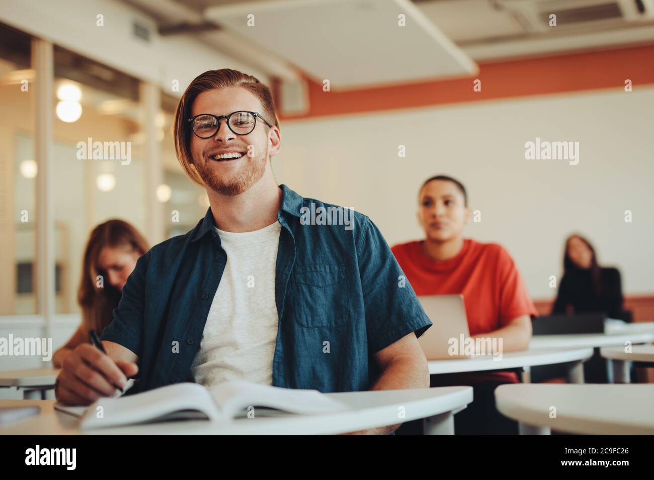 Portrait of young male student in high school classroom. Young man in ...