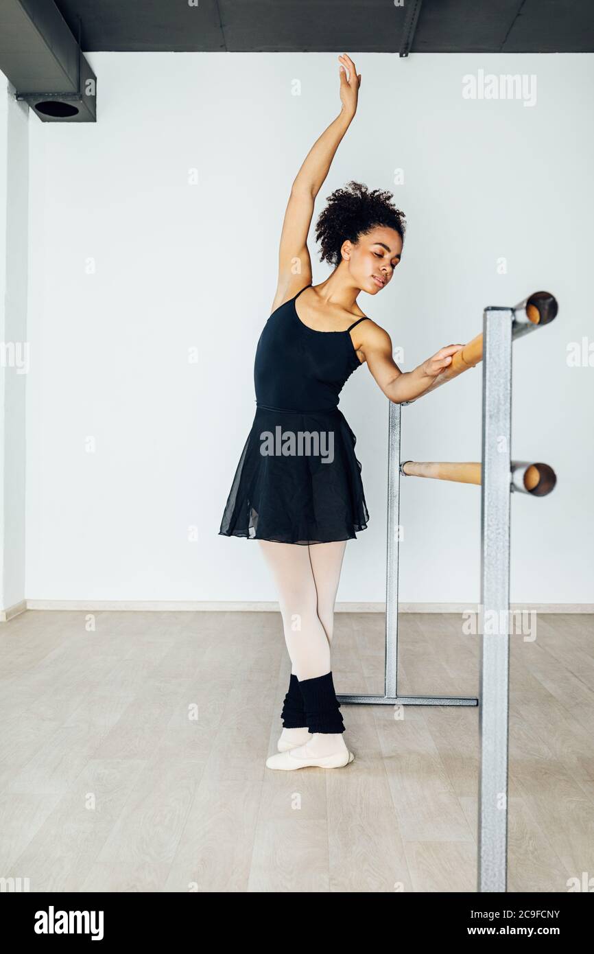 Young artist practicing ballet moves in the studio at barre Stock Photo ...