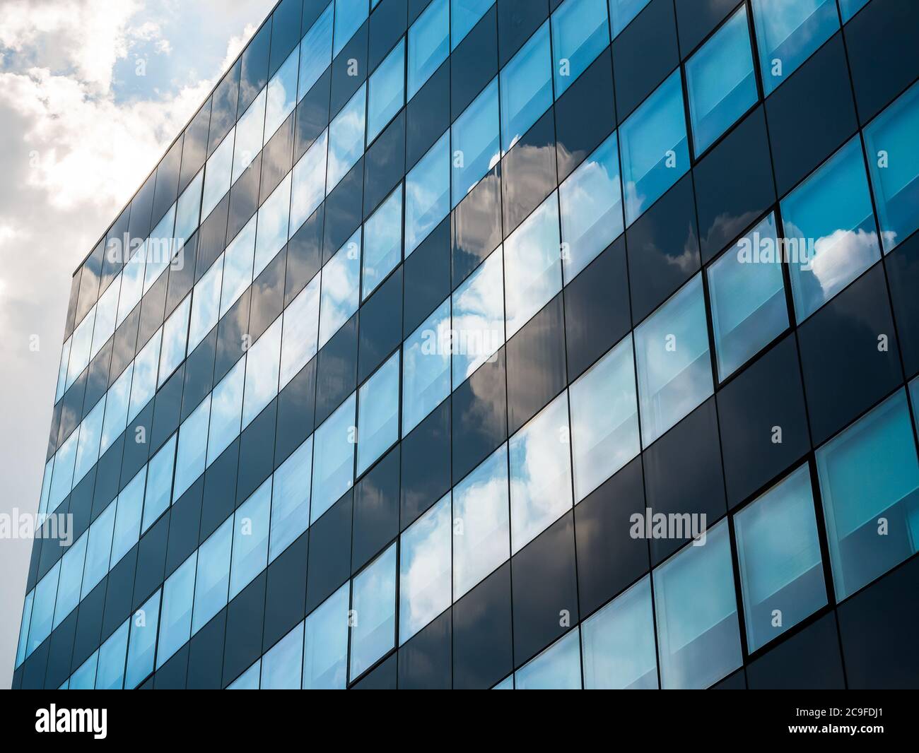 Modern skyscraper in business district with the sky reflecting in the ...