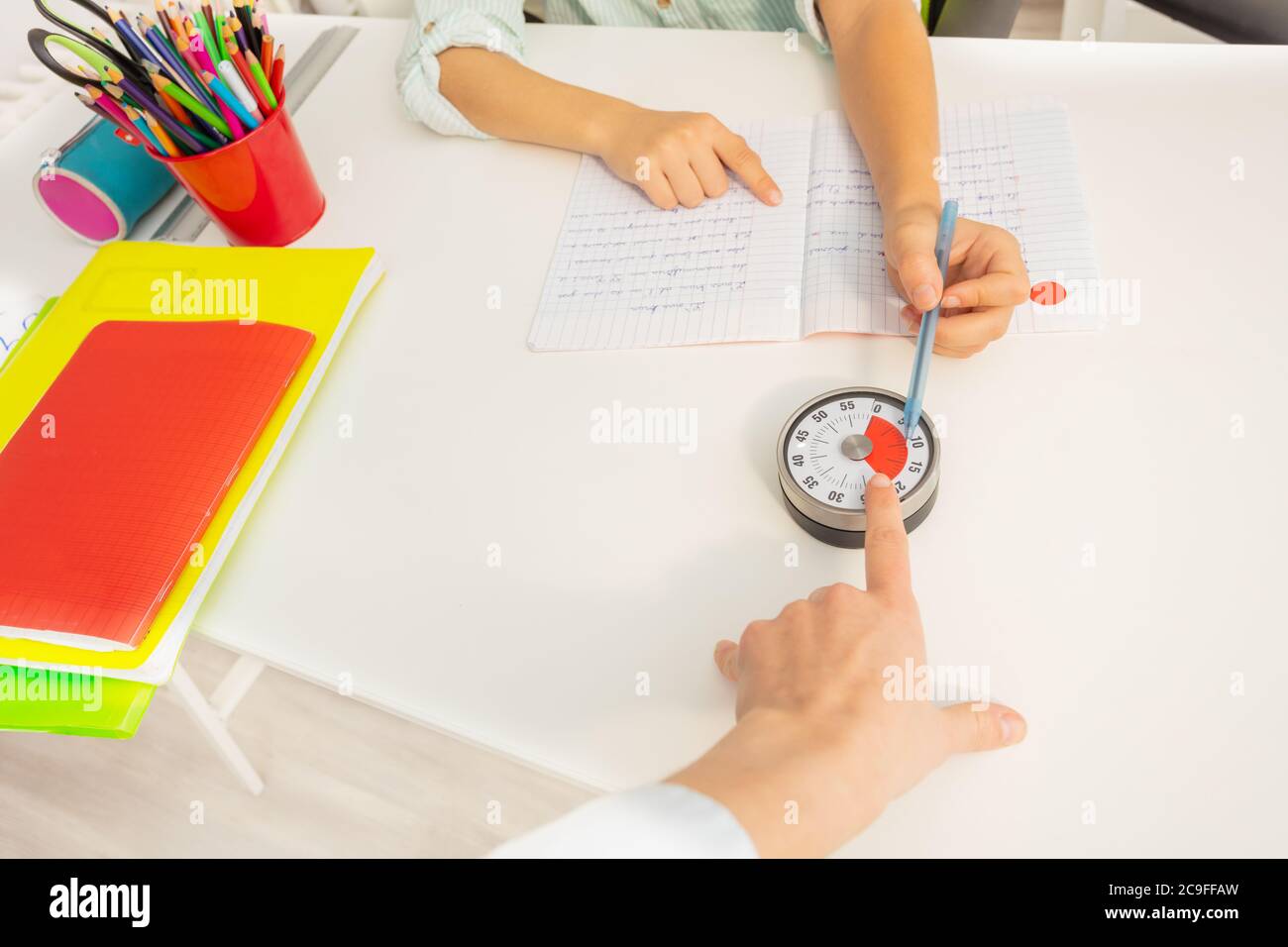 Teacher woman's hand point to the lesson timer during development class ...