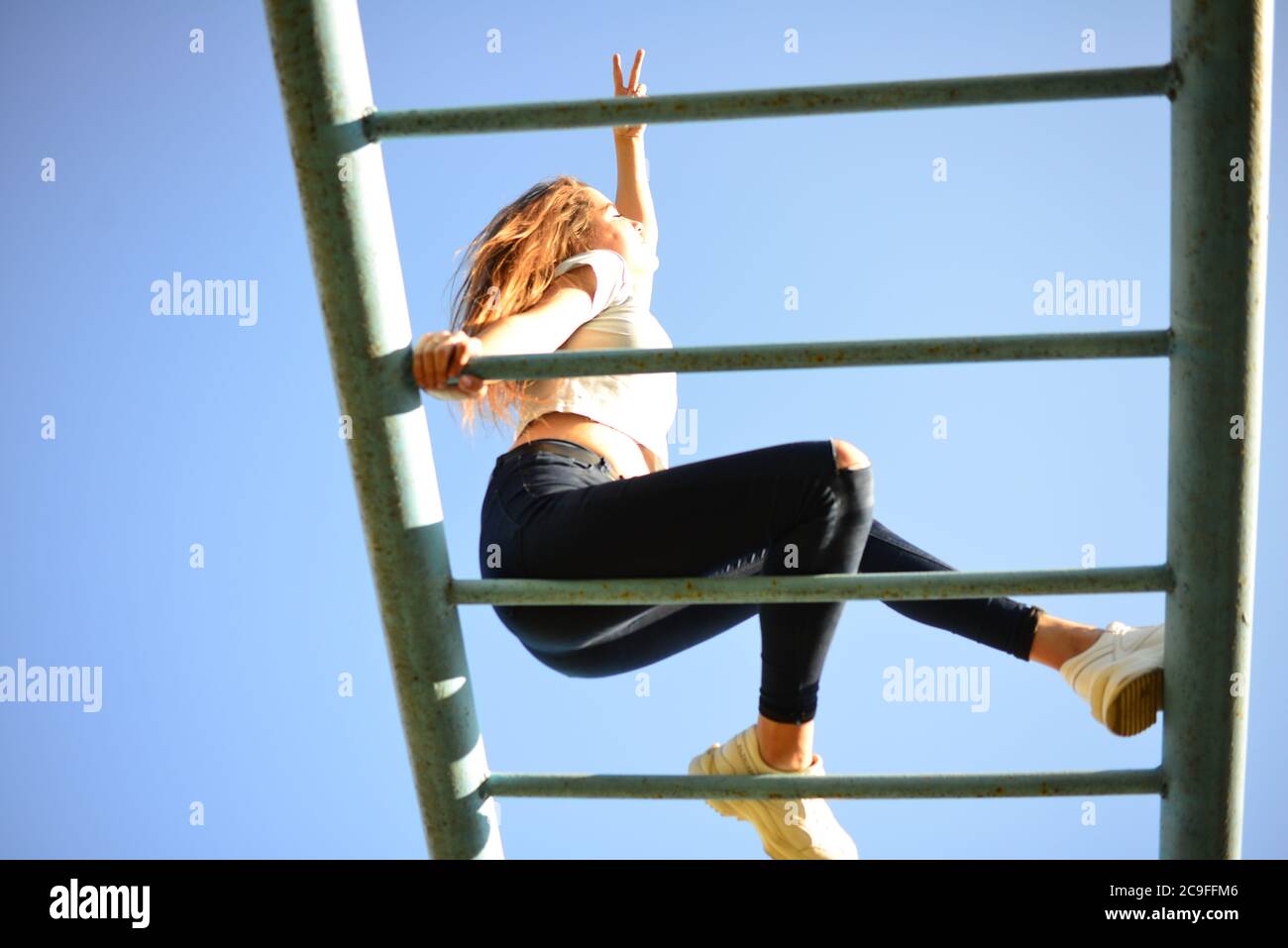 Girl climbs the stairs to the sky background in the playground Stock ...