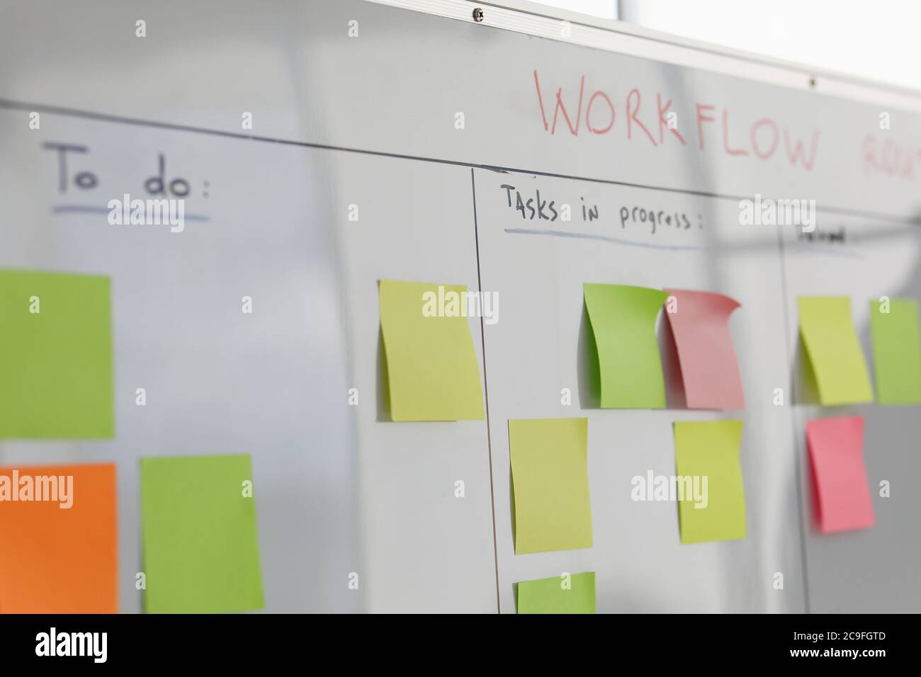 On white board multicolored stickers with business tasks are glued ...