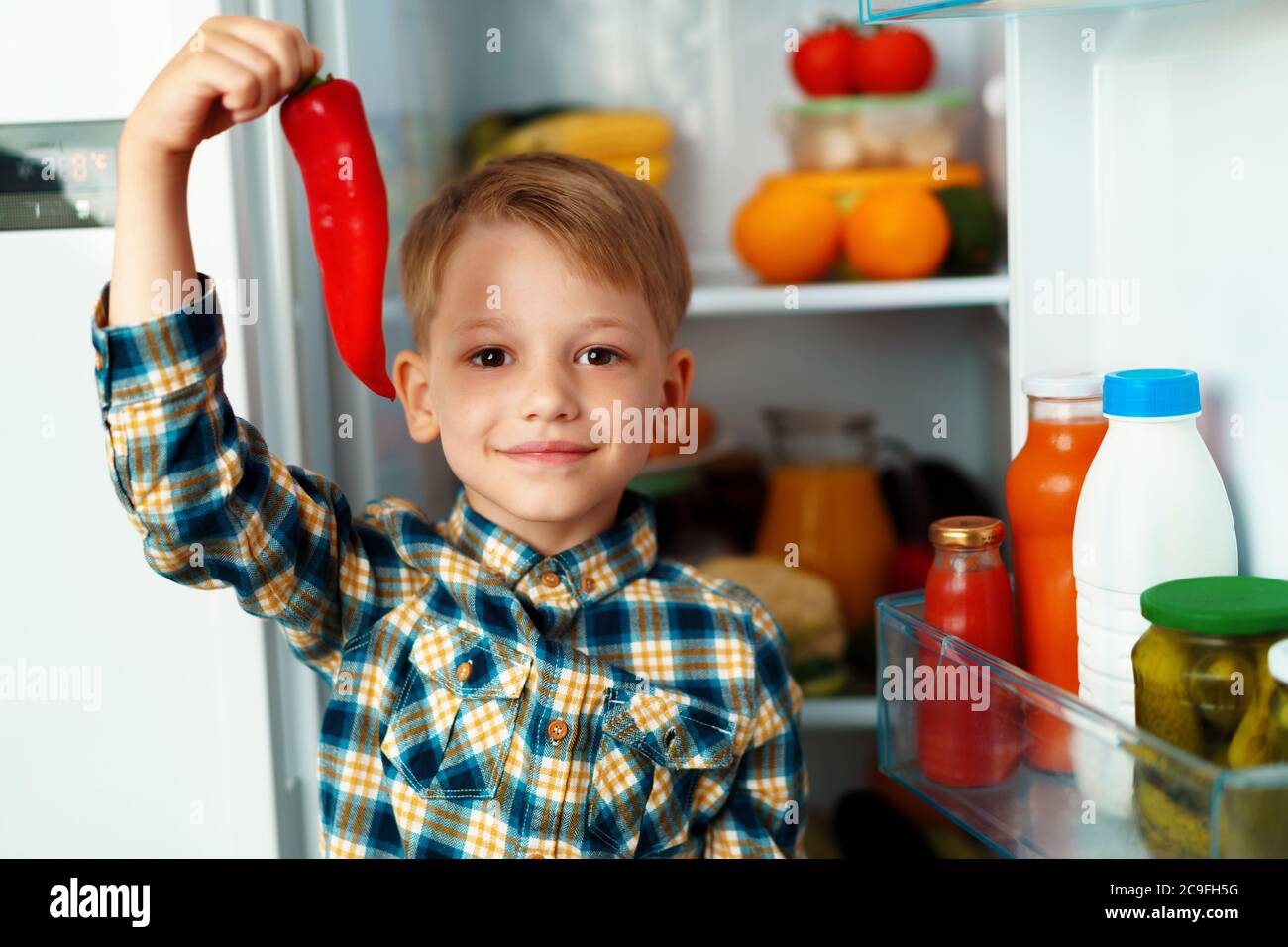 Little boy standing in front of open fridge and choosing food Stock ...